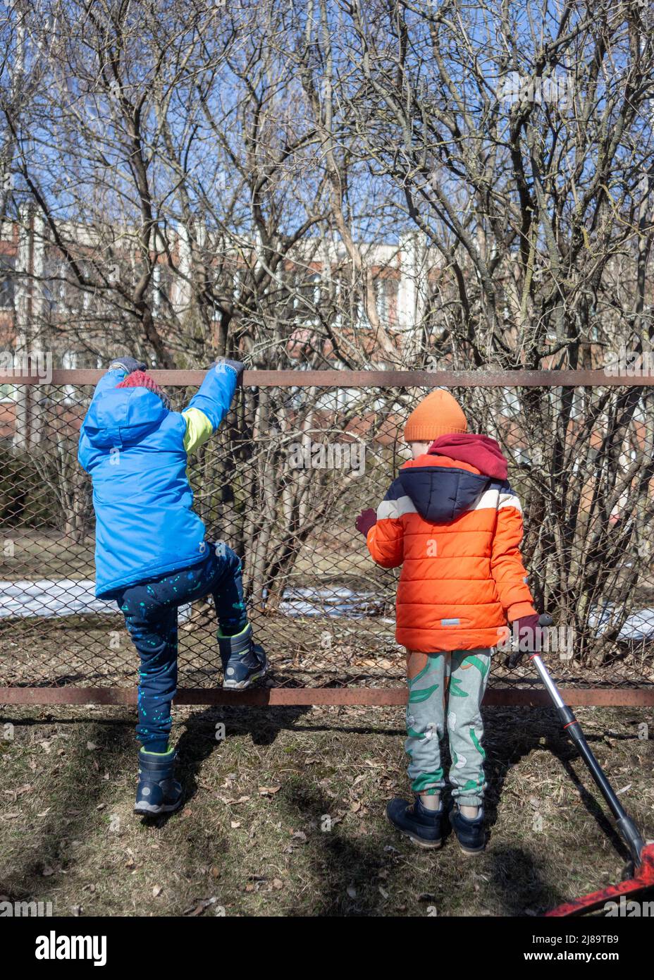 Two children climb over the fence. .Children's games Stock Photo - Alamy