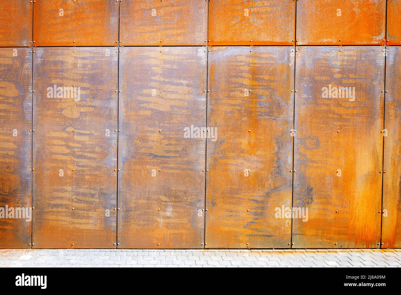 Modern architecture rusty metal wall and a sidewalk Stock Photo - Alamy