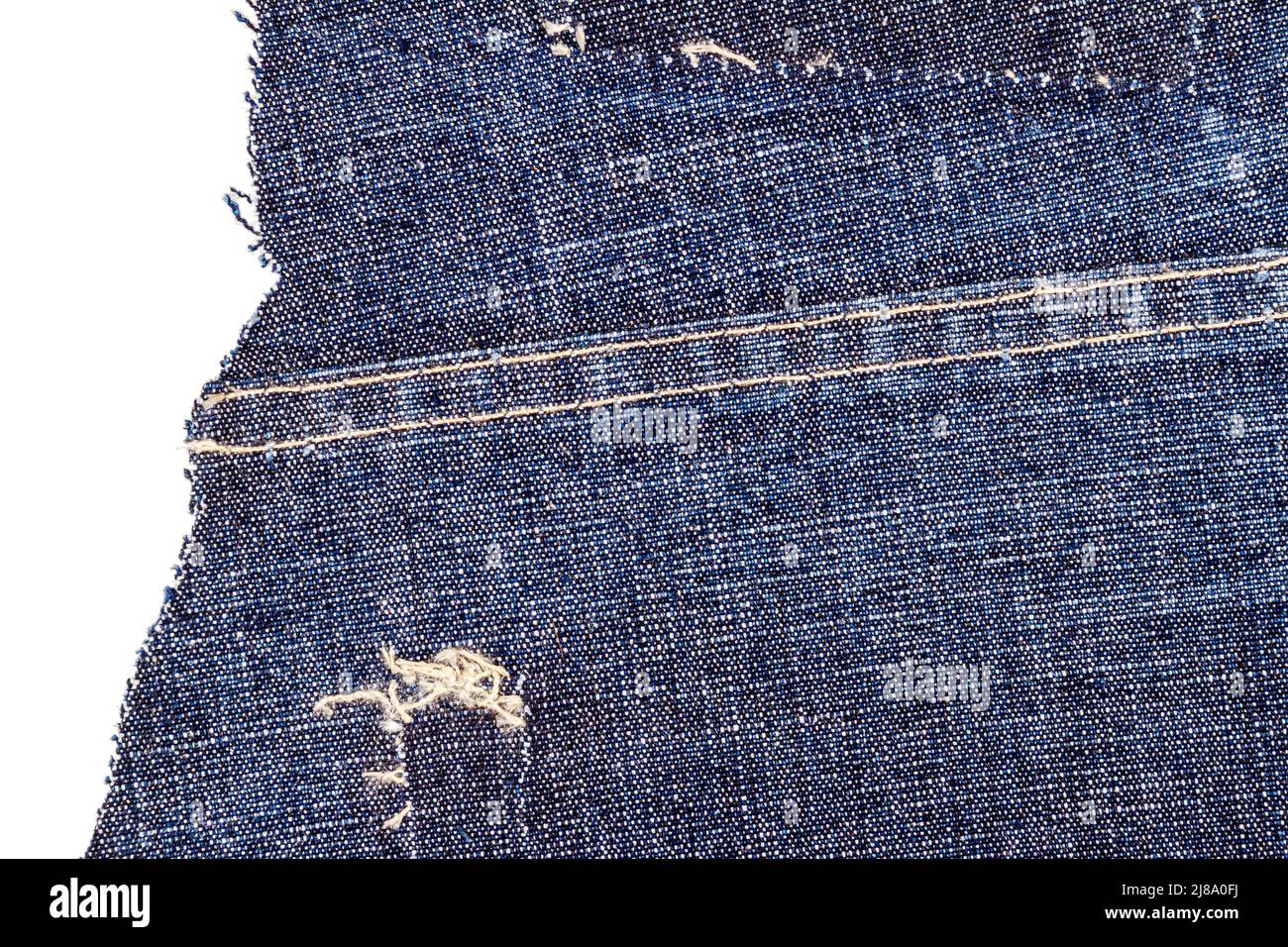 Piece of blue jeans fabric with a ripped of back pocket isolated on ...