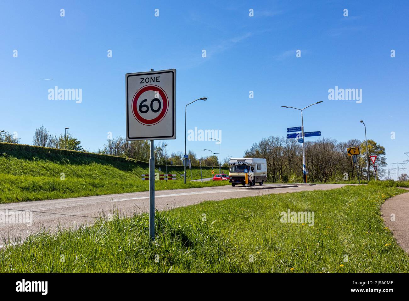 Rural road with a traffic sign: maximum speed zone 60, cars circulating ...
