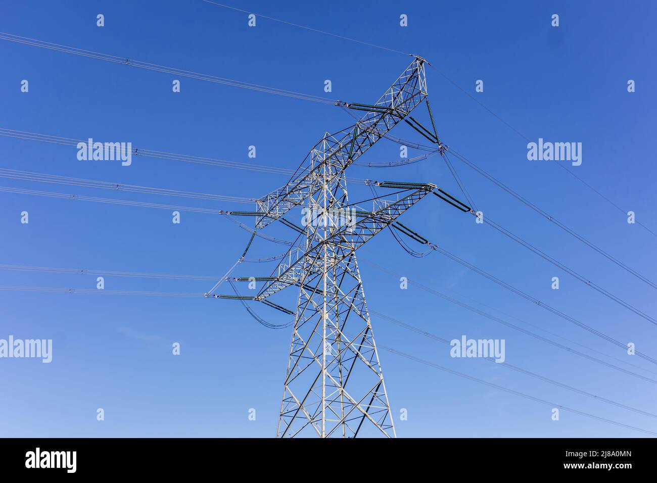 Top of a huge high-voltage electric tower, sunny day with a clear blue ...