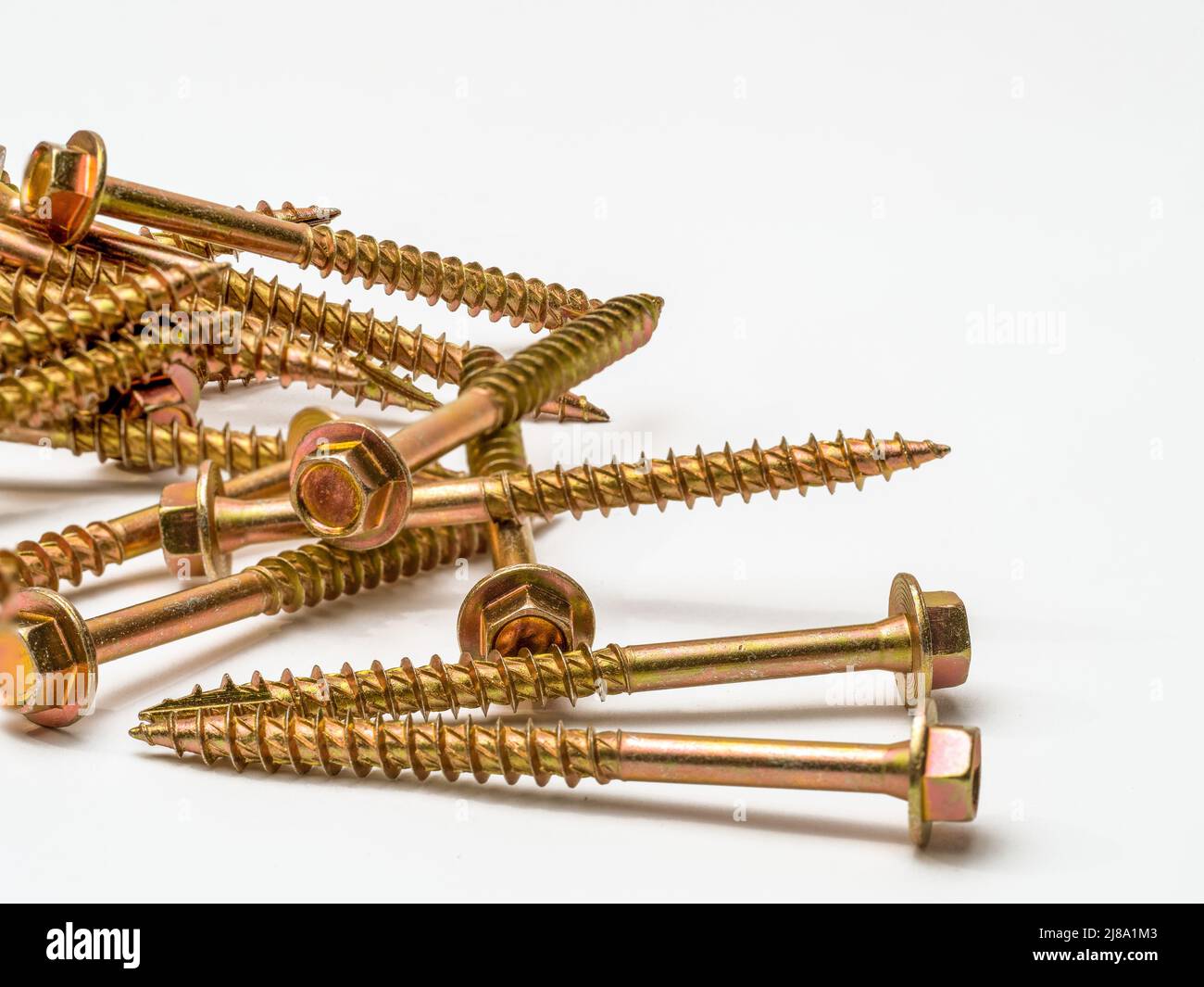 loose pile of yellow zinc anodised coach bolt screws for woodworking on a white background Stock ...