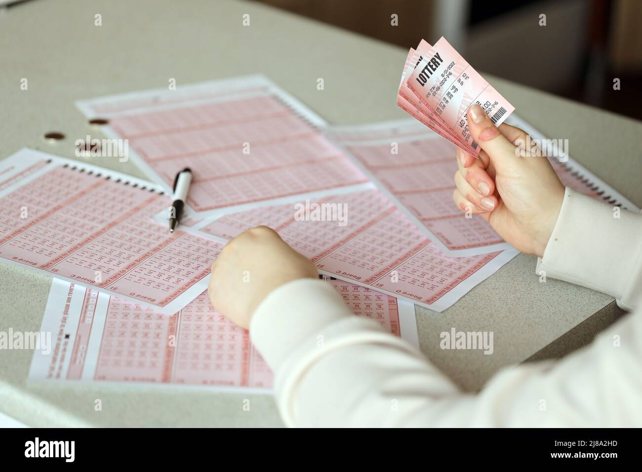 Filling out a lottery ticket. A young woman holds the lottery ticket ...