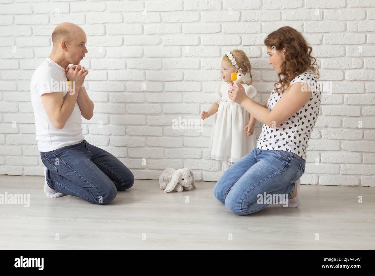 Baby child with hearing aids and cochlear implants plays with parents ...