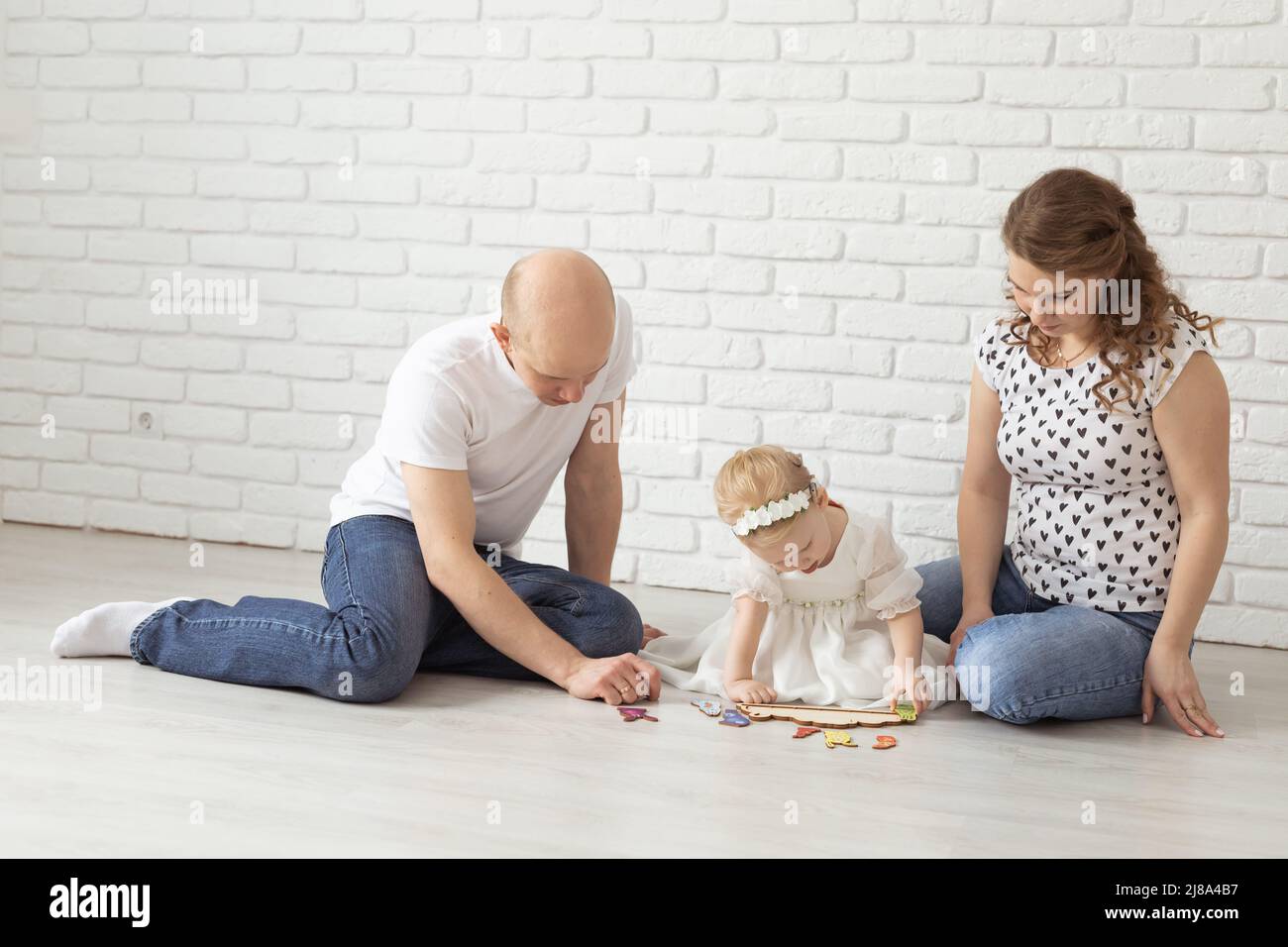 Baby child with hearing aids and cochlear implants plays with parents ...