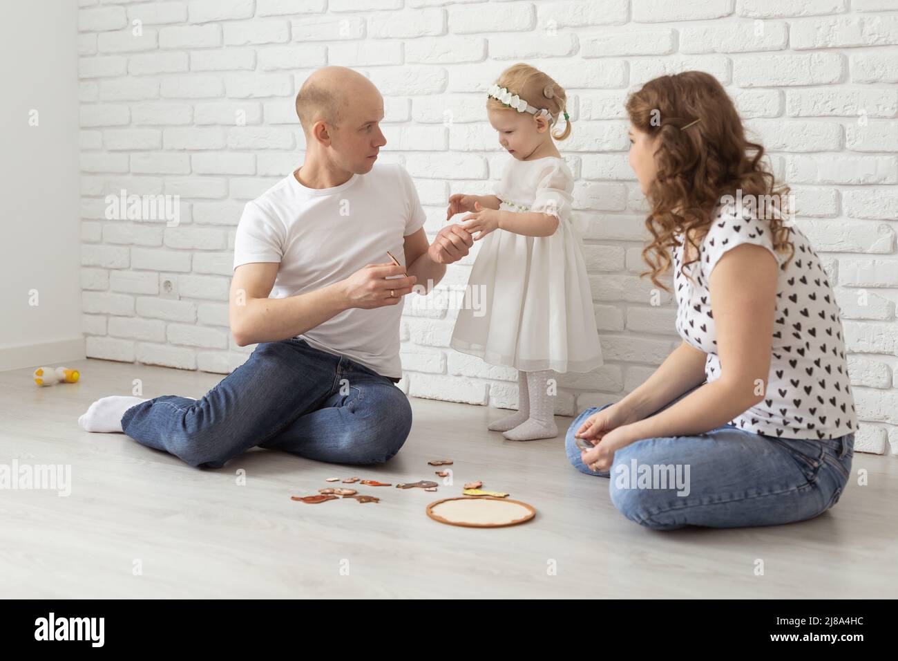 Baby child with hearing aids and cochlear implants plays with parents ...