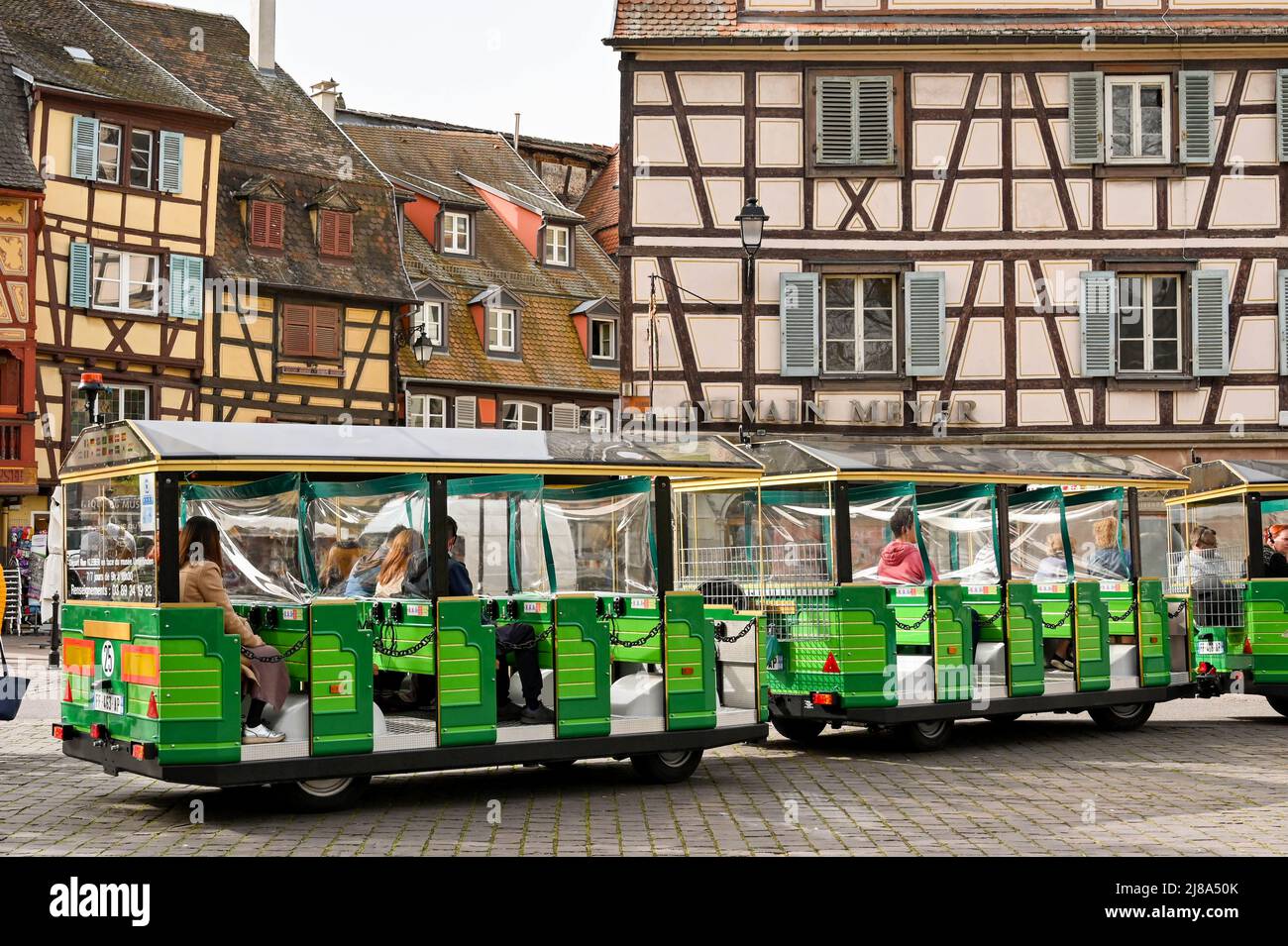 Colmar, France - April 2022: People sitting in a tourist land train ...