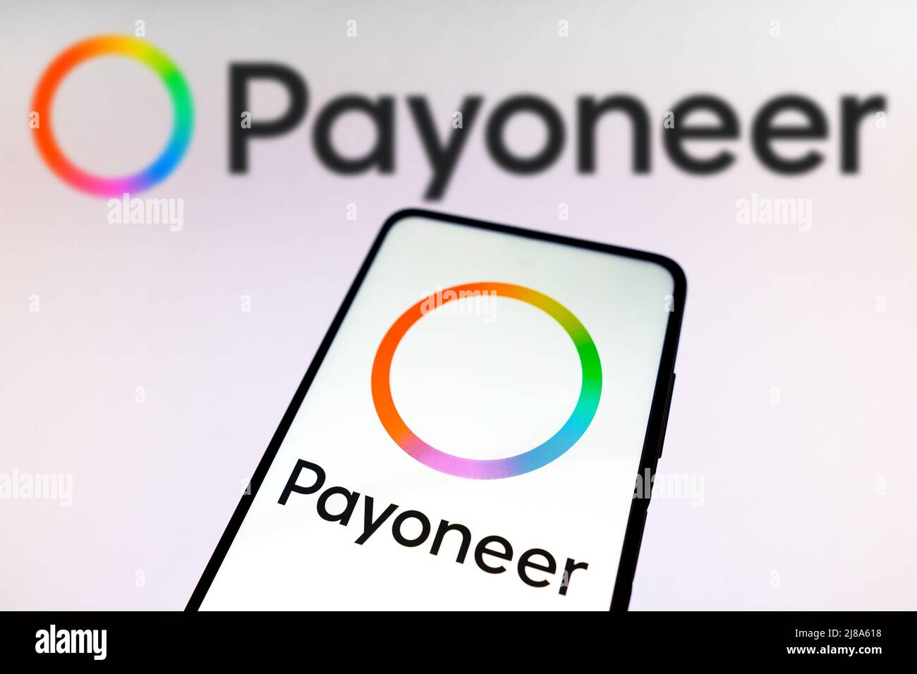 In this photo illustration the Payoneer logo seen displayed on a ...