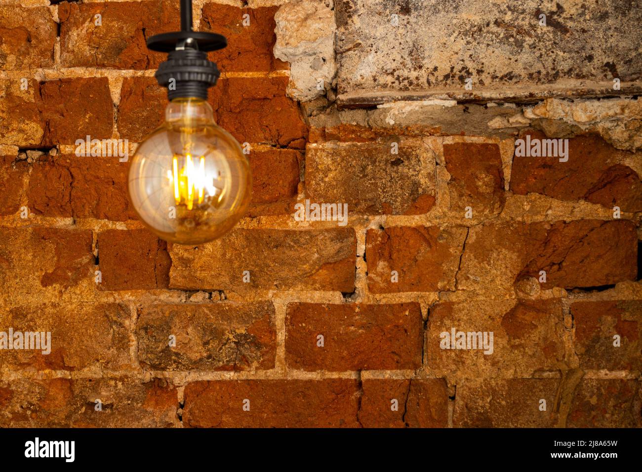 brick old wall and a burning electric lamp. Loft interior concept Stock ...
