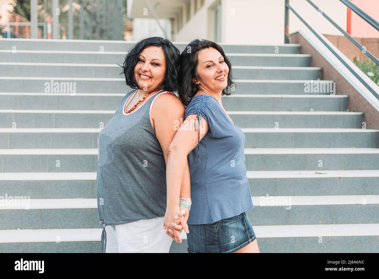 Portrait of two adult brunette twin sisters. Different styles Stock ...