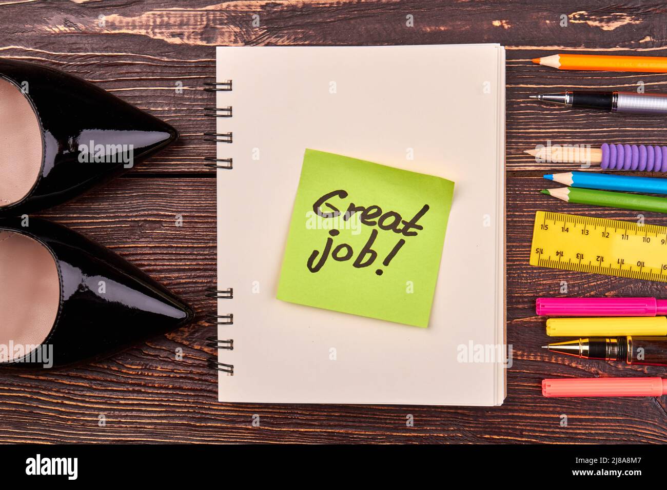 Great job concept flat lay top view. Sticky note with notepad and shoes ...