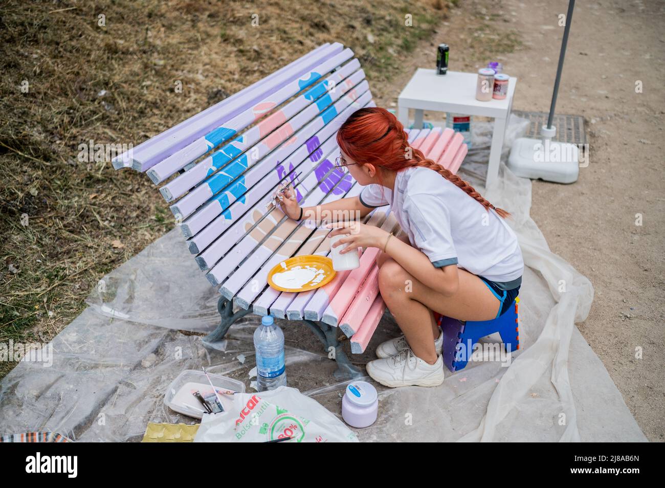 Local young illustrator Carla Loza paints a wooden bench at popular ...