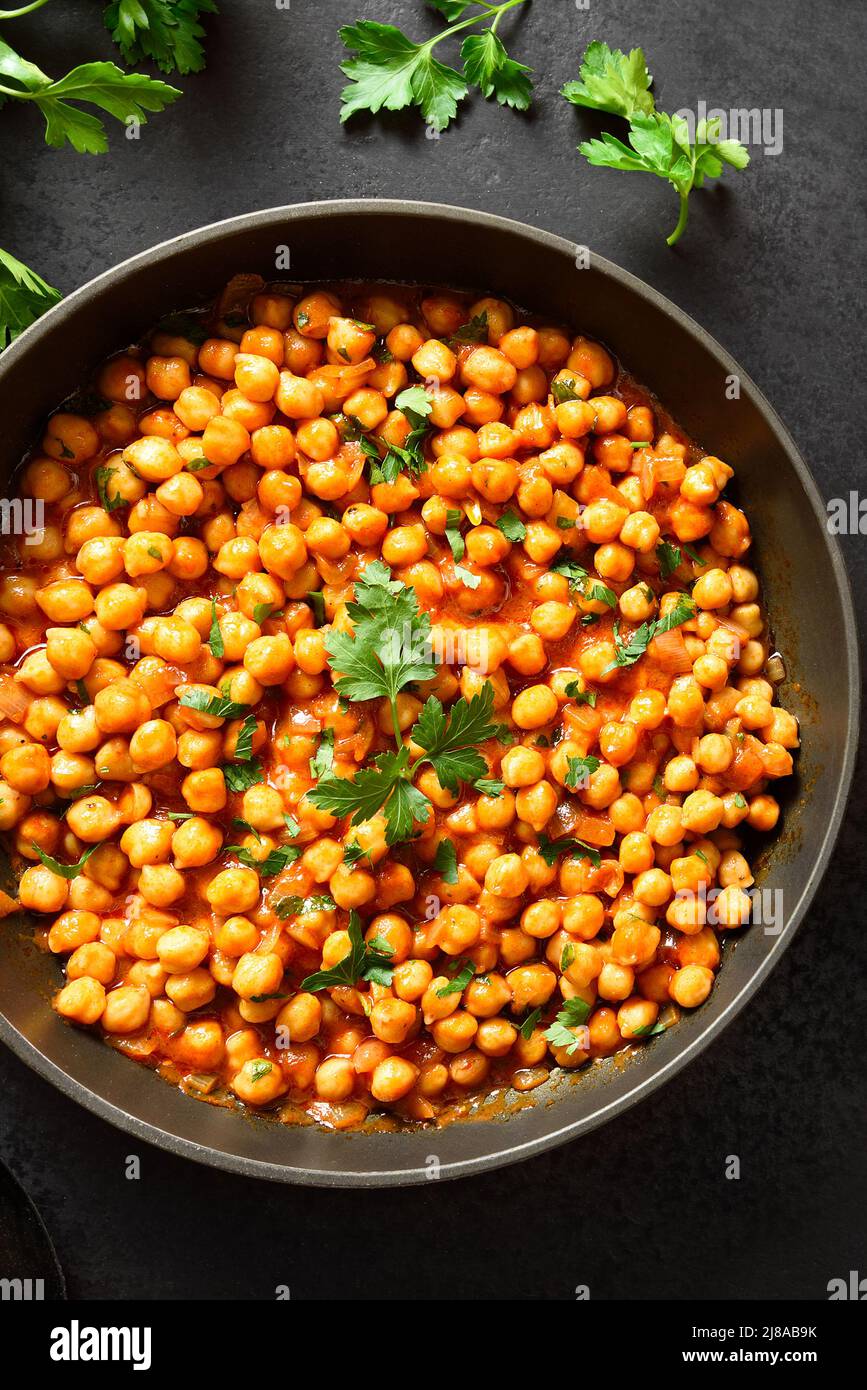 Crispy roasted chickpeas. Indian style dish over black stone background ...