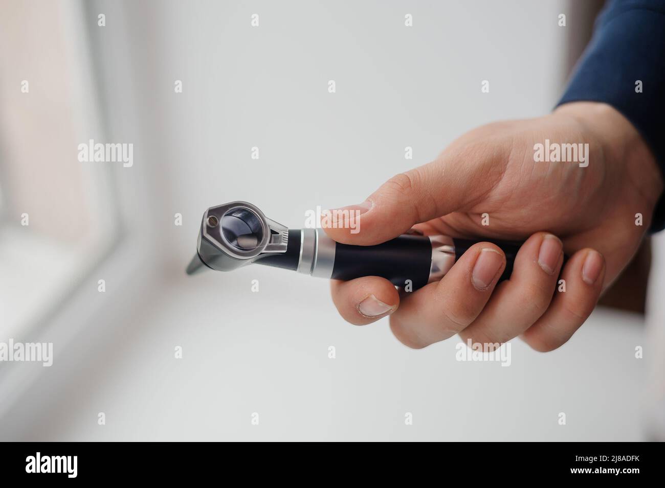 Otoscope on a background in the hand of an otolaryngologist. Instrument ...