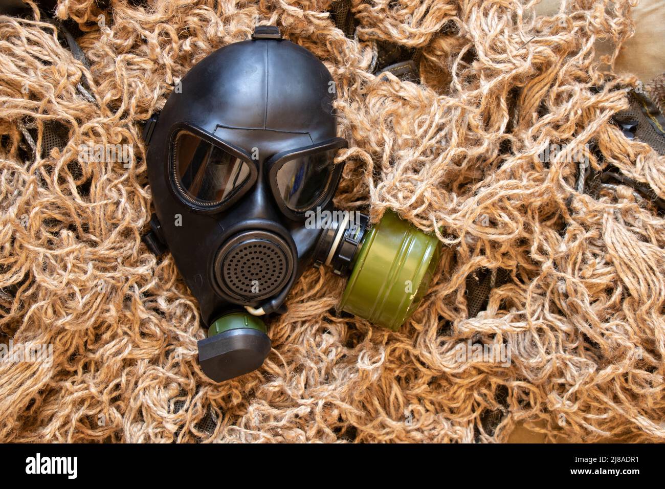 Black gas mask lies on a camouflage military suit, gas attack, military ...