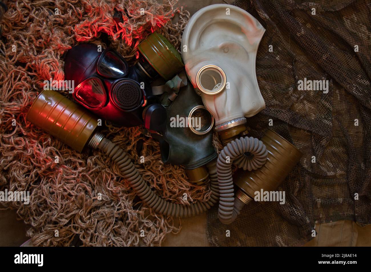 Three different gas masks lie on a camouflage military suit, gas attack ...