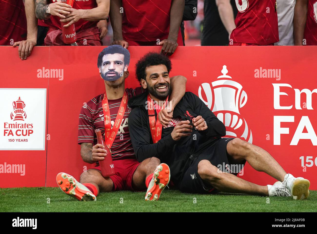 Liverpool's Thiago Alcantara (left) wears a mask of team-mate Mohamed ...