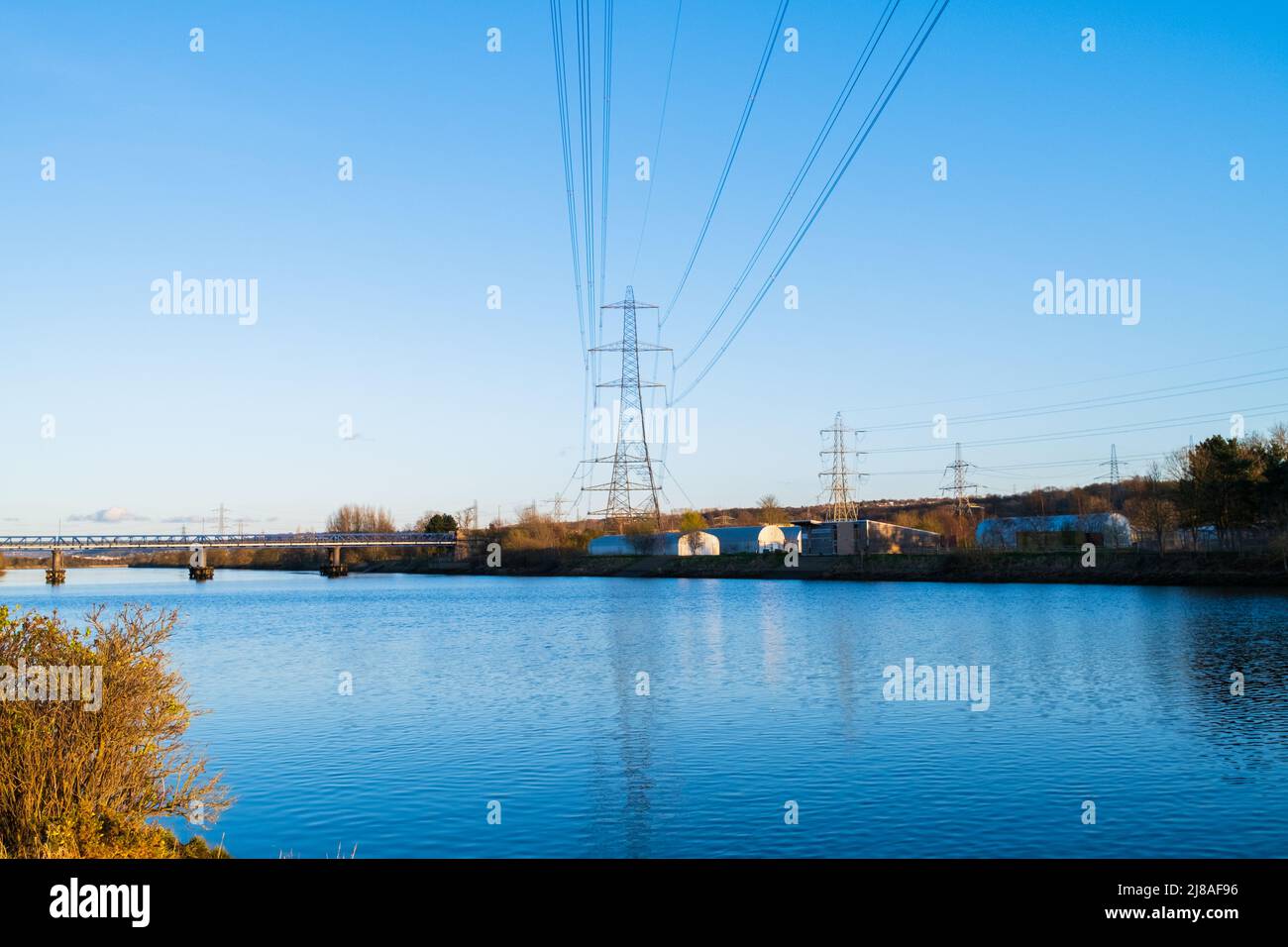 Pylon power lines against a deep blue sky crossing the River Tyne at ...