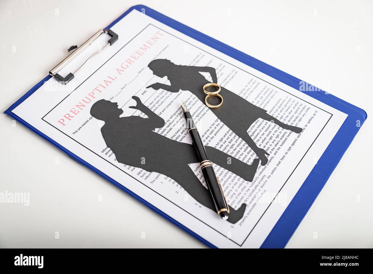 Marriage contract with two golden wedding rings and gold pen ...