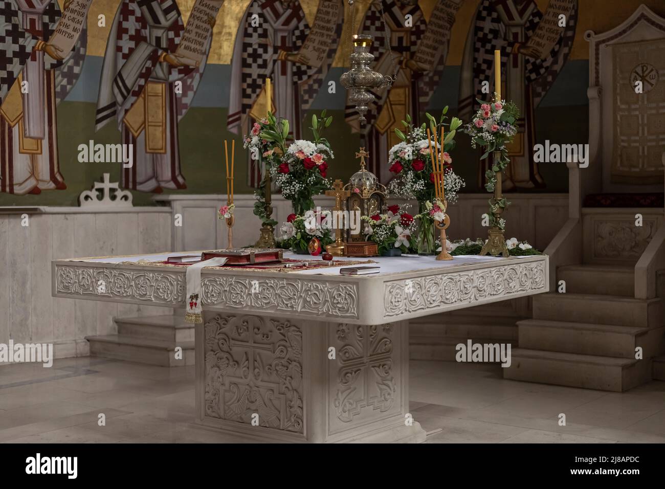 Ornate white carved table in a church containing various religious ...