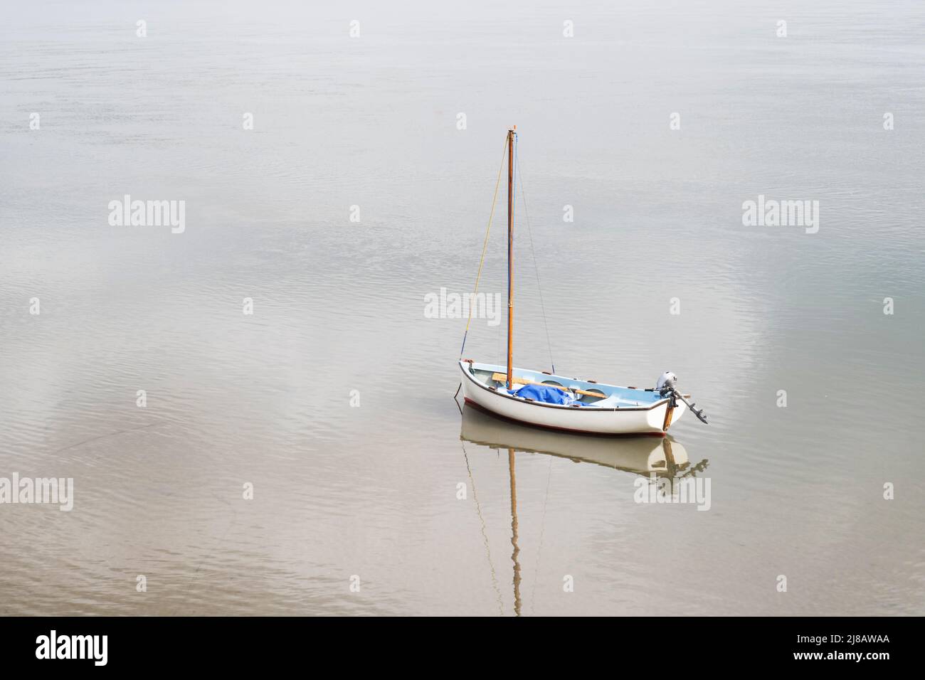 Small sailing boat on calm water with reflections Stock Photo - Alamy
