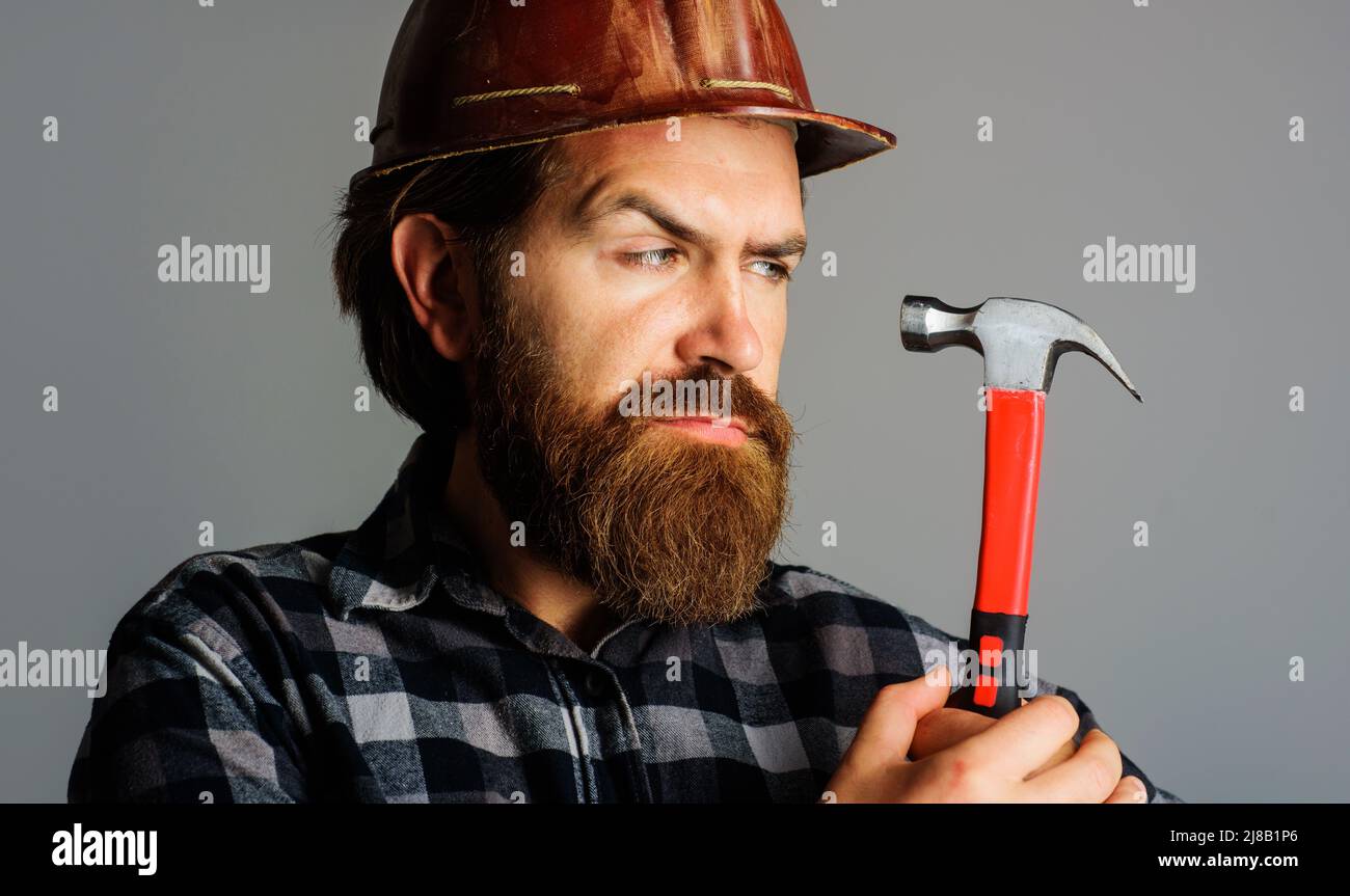 Builder in hard hat with hammer. Portrait of bearded workman in hardhat ...