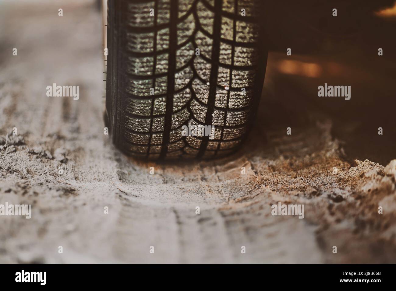 A view from below of a car standing with tires on a sandy road during ...