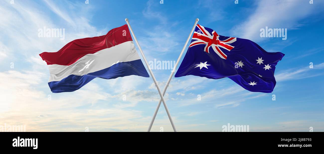 two crossed flags netherlands and Australia waving in wind at cloudy ...