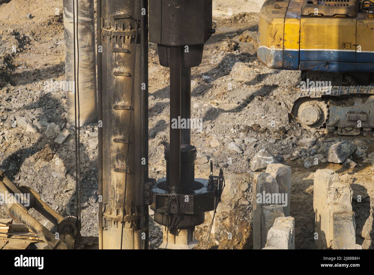 The pile driver drives the pile into the ground Stock Photo - Alamy