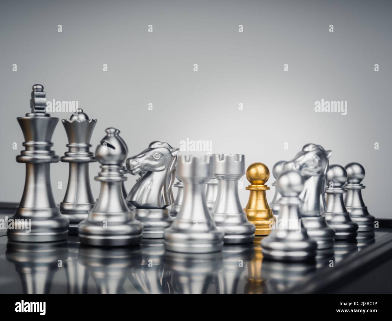The golden pawn chess piece standing stand in the middle many silver ...