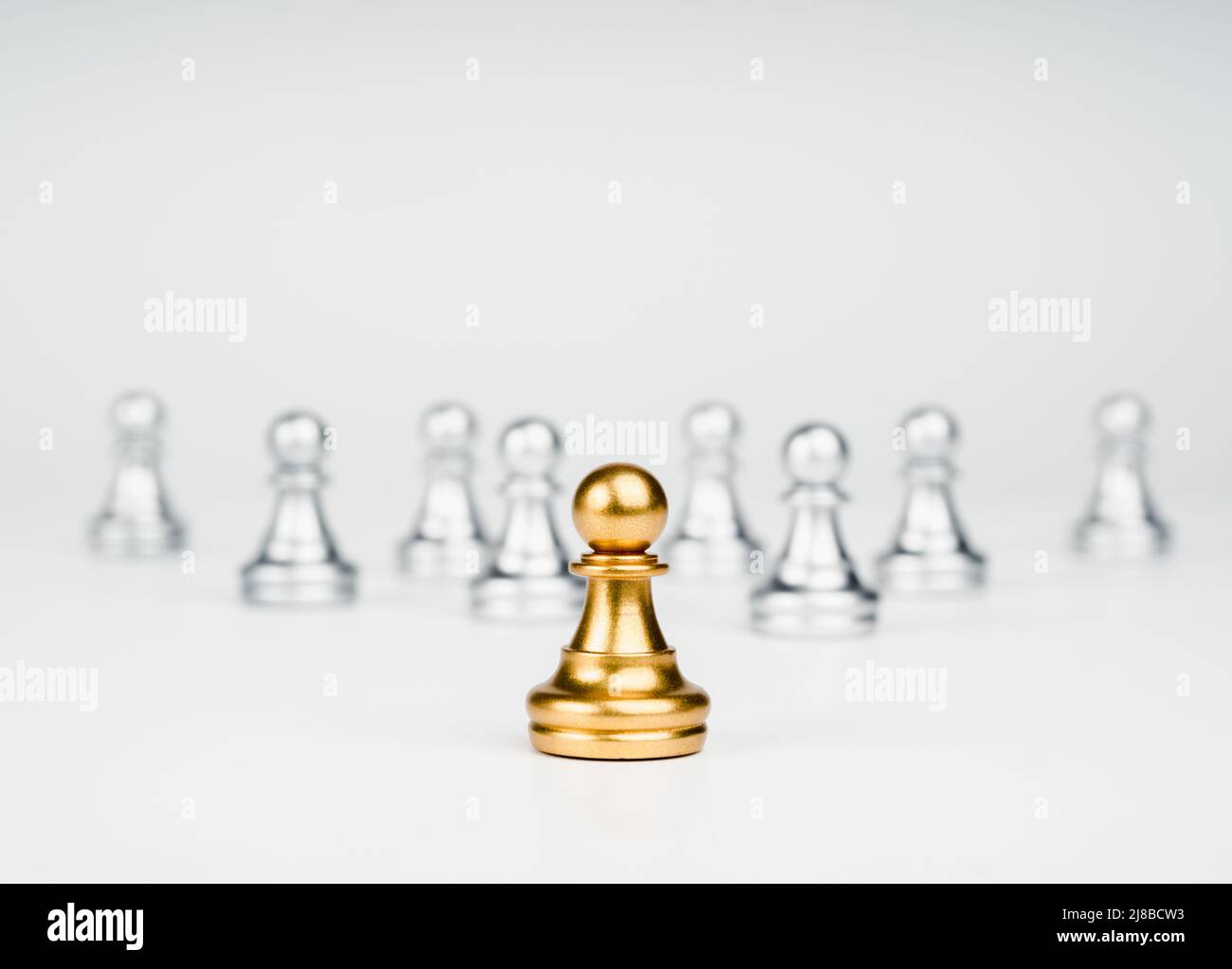 The golden pawn chess piece standing out from the group of silver pawn ...