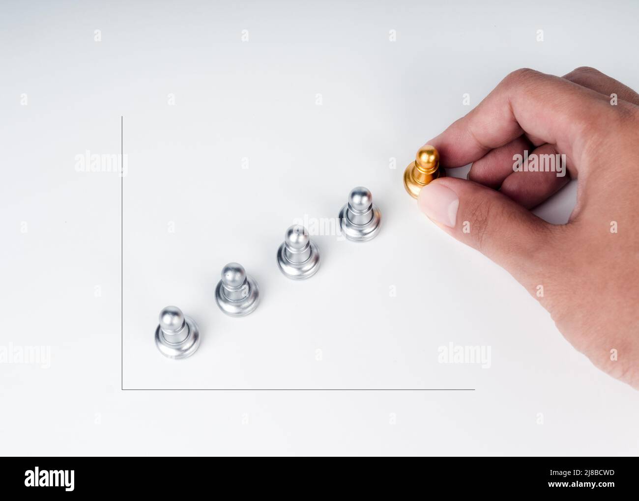 The golden pawn chess piece moves up by hand from the silver pawn chess ...