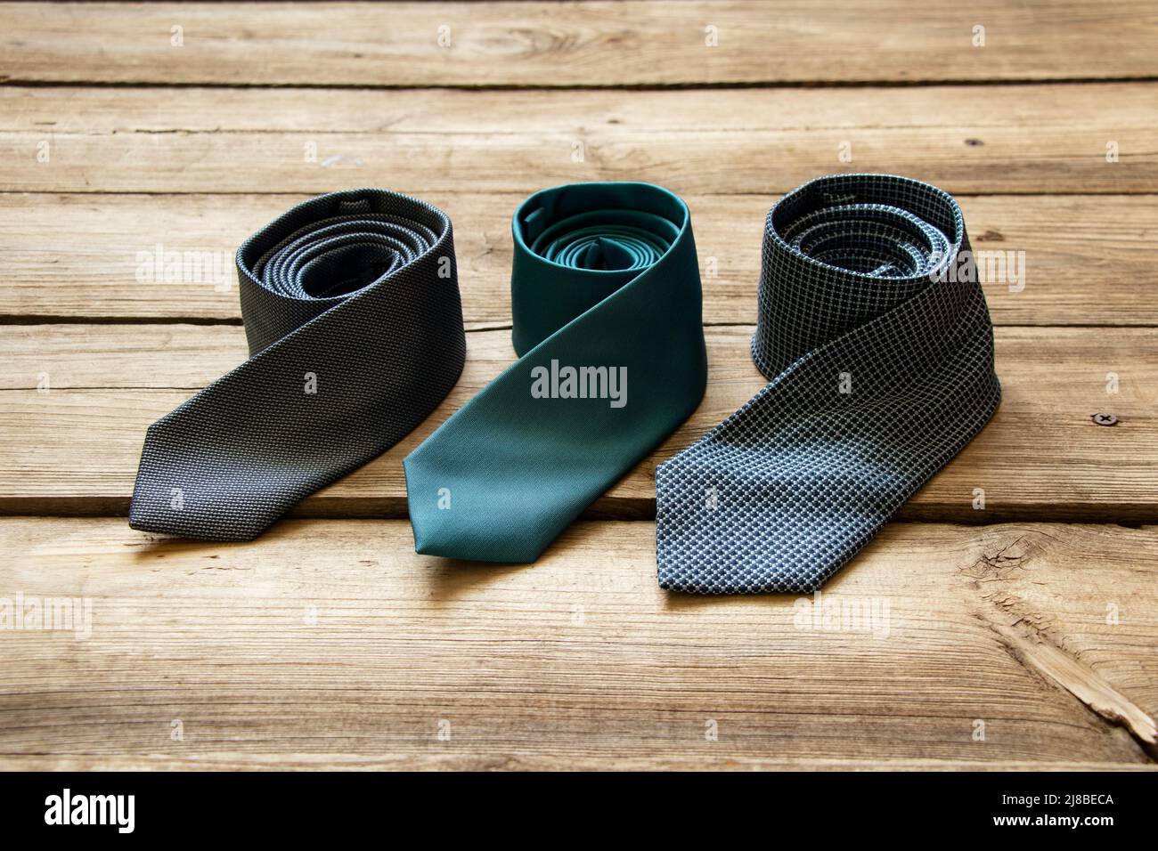 Three blue ties lie on a wooden table, different men's ties close-up ...