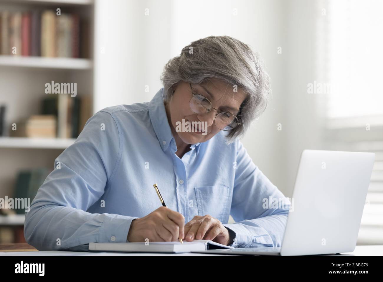 Serious busy mature lady working at laptop computer Stock Photo - Alamy