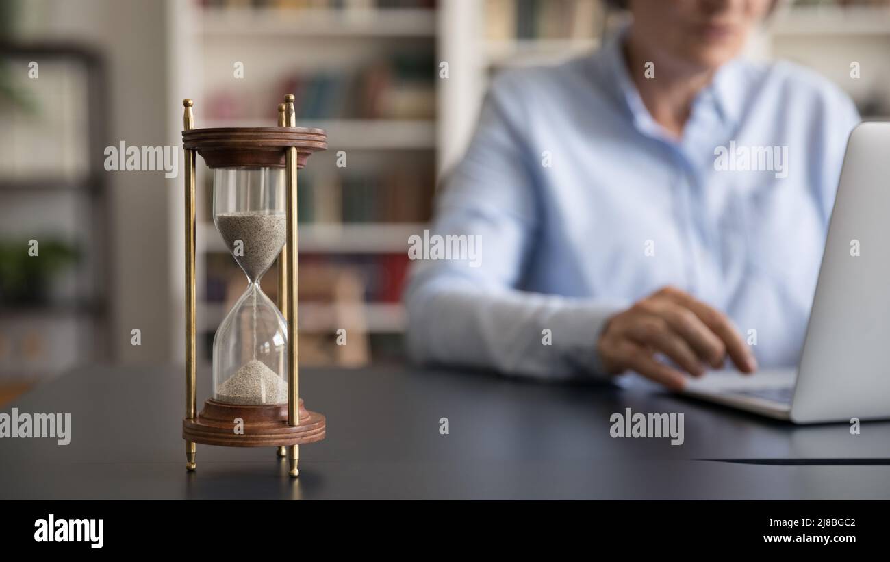 Vintage sand watch on work table of senior business lady Stock Photo ...