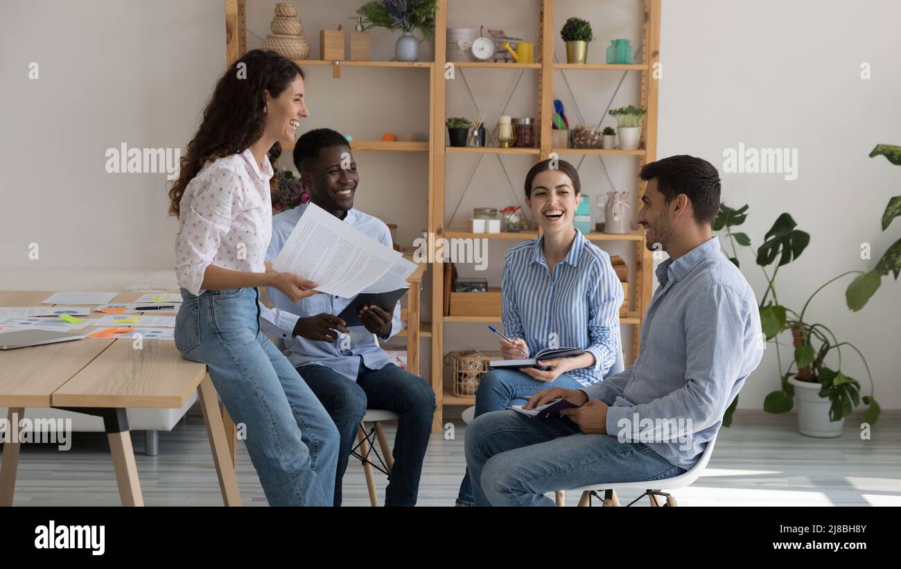 Cheerful excited multiethnic business group brainstorming, sharing ...