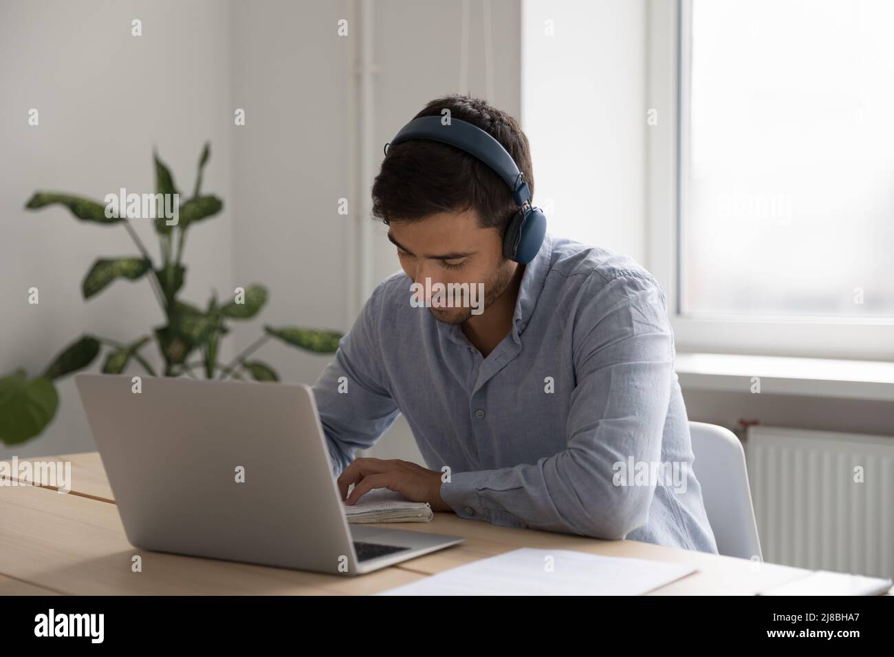 Positive college student guy writing notes at laptop Stock Photo - Alamy