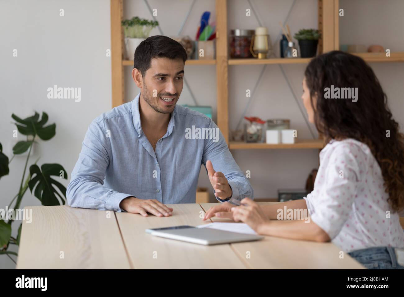 Handsome confident business project leader, boss instructing employee ...