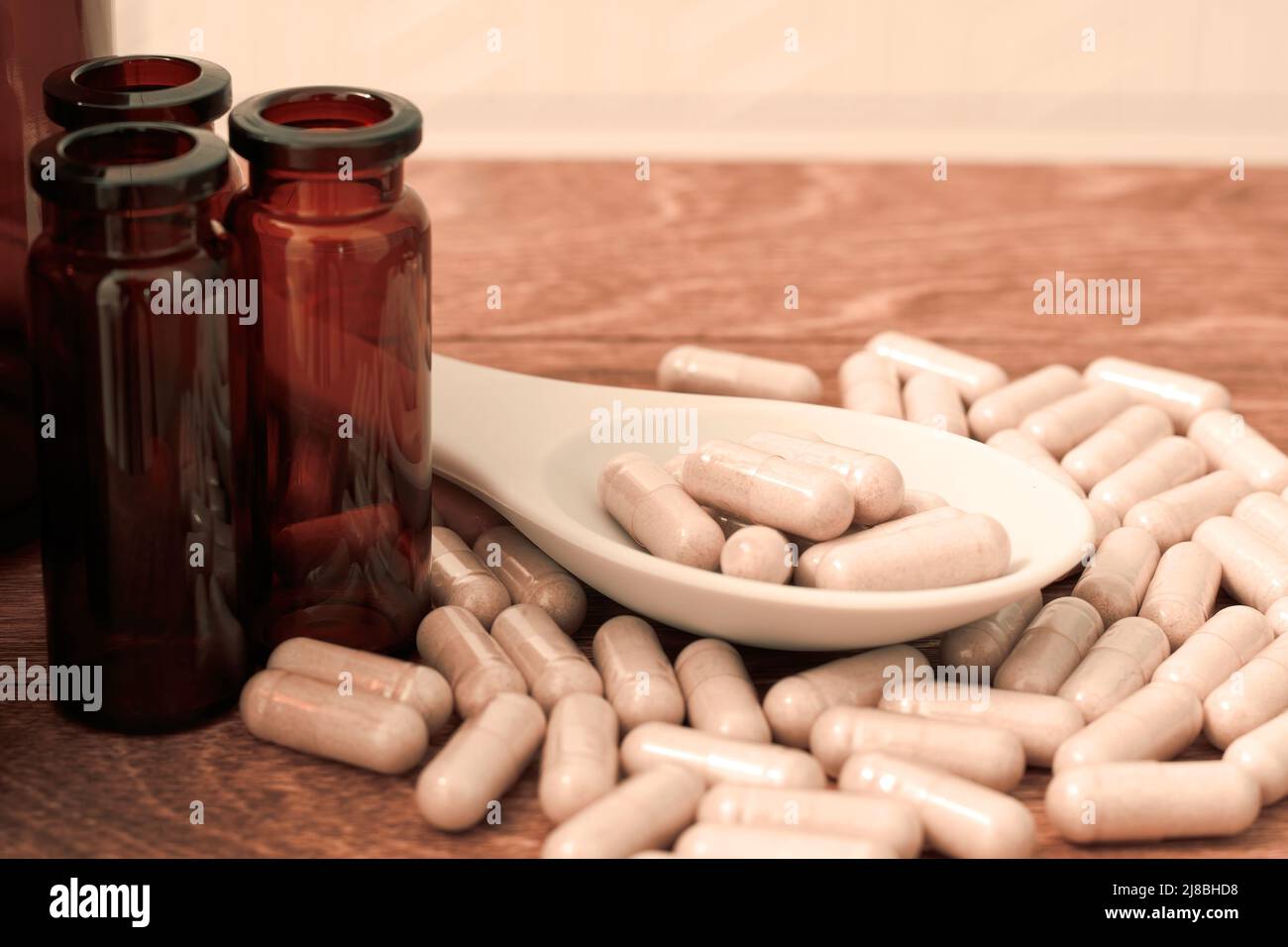 Medical dietary supplement pills on the spoon with brown vials ...