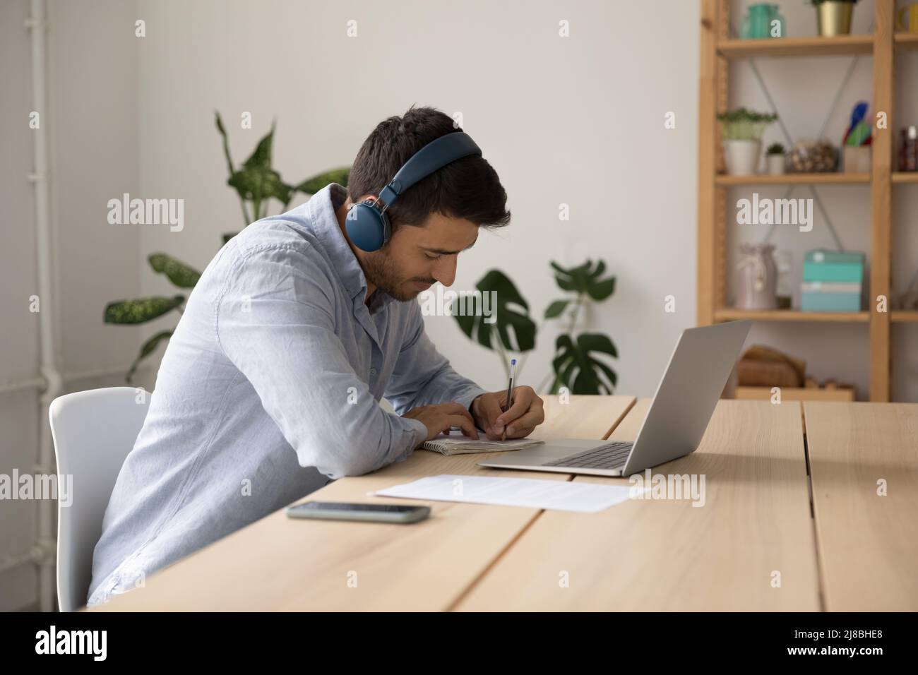 Focused young student guy in earphones watching virtual class Stock ...