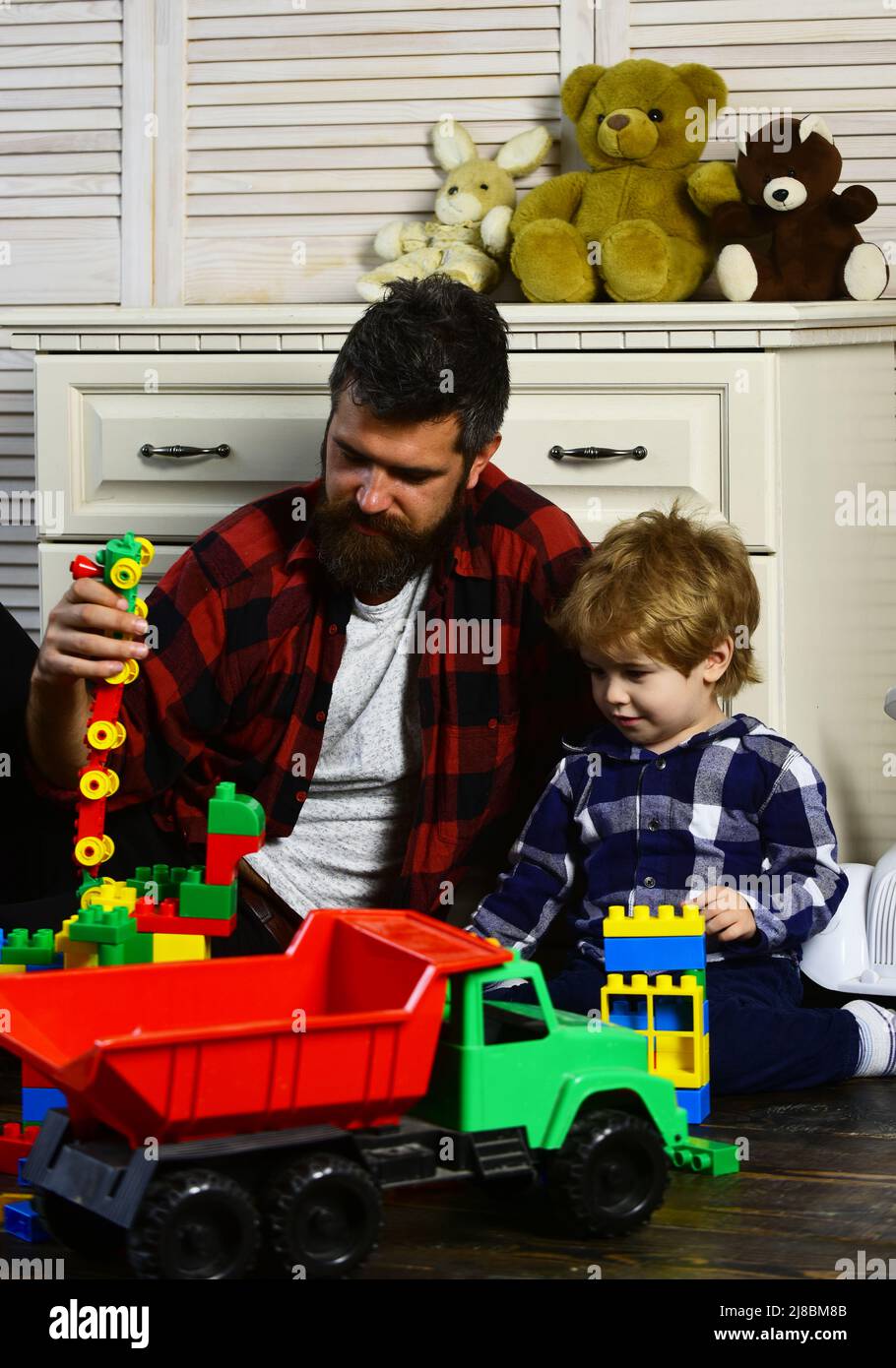 Kid and dad play lego toys. Father and son create toys from bricks. Dad ...