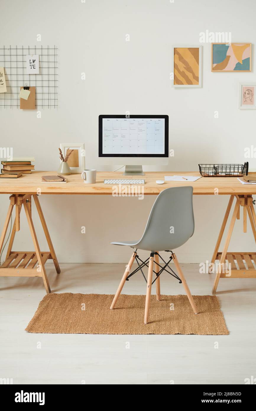 Modern computer with online calendar on screen placed on wooden desk ...