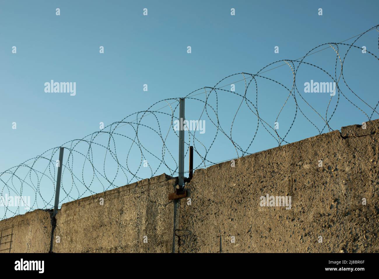Barbed wire fence. Fence of territory. Concrete obstacle. Wall of ...