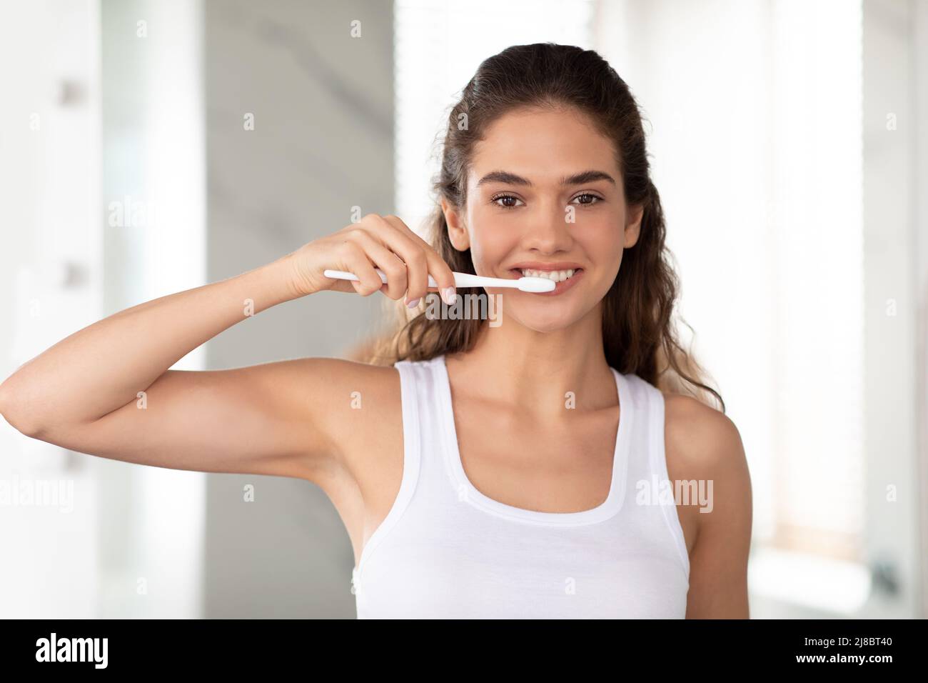 Happy Young Woman Posing With Toothbrush Brushing Teeth In Bathroom ...