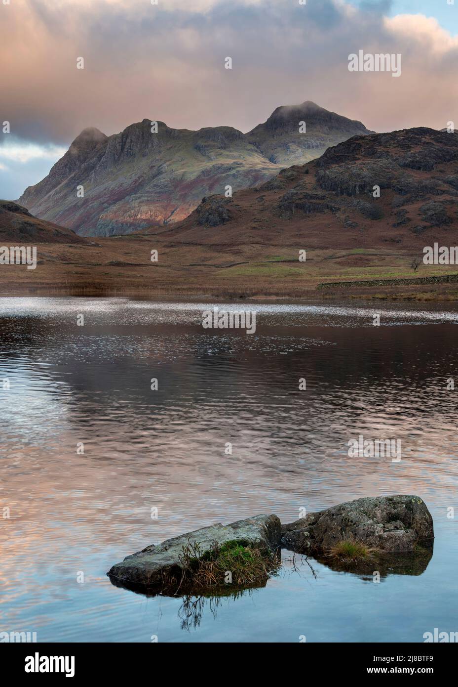 Epic landscape of sunrise light over Blea Tarn in Lake District with ...