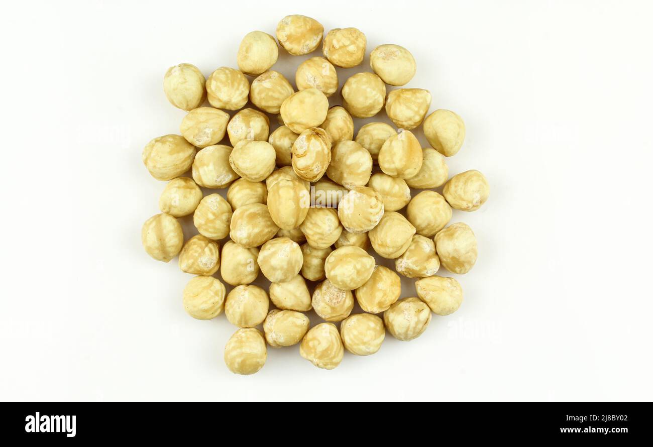 Pile of golden color roasted hazelnuts isolated on white background ...