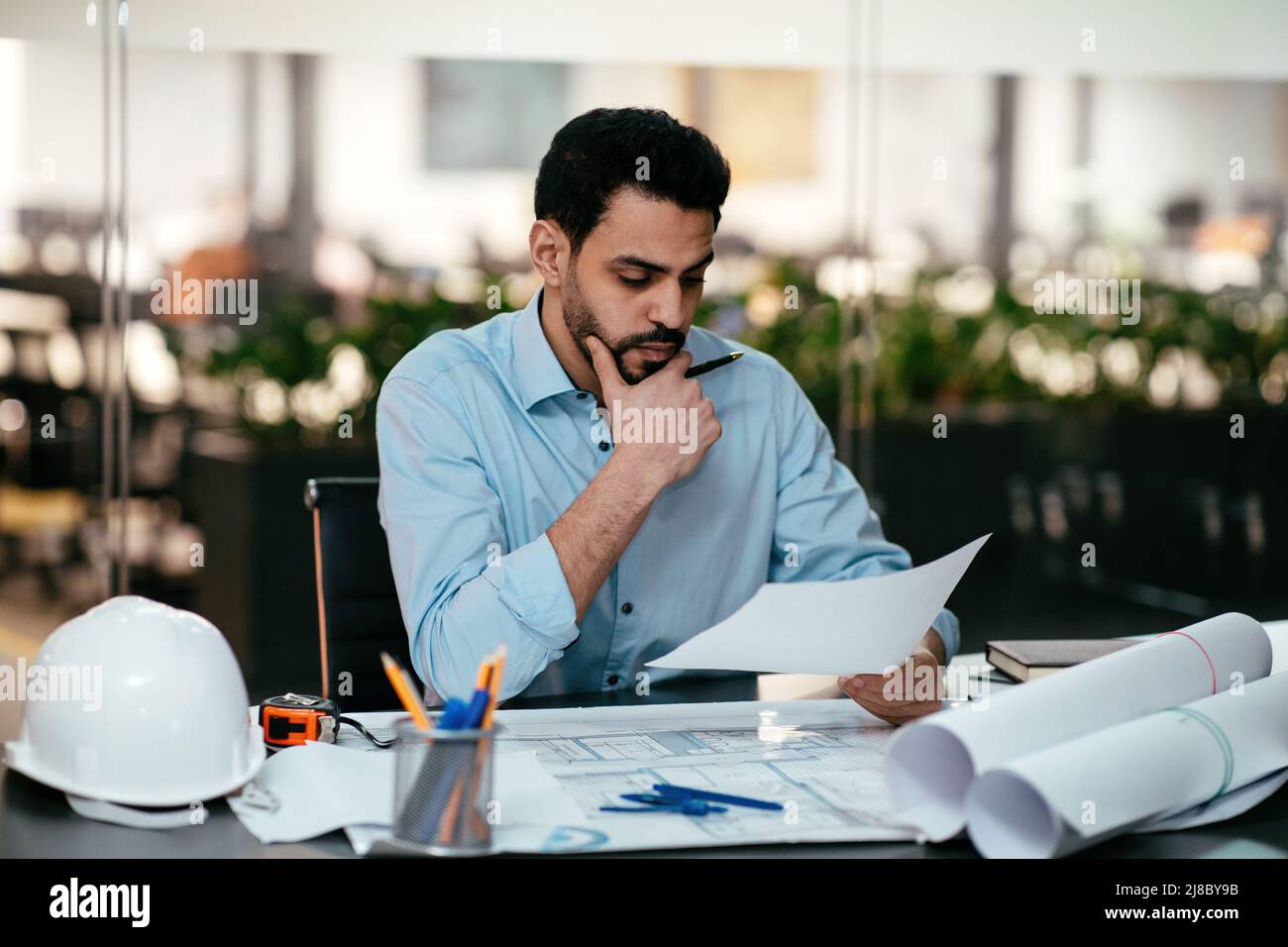 Busy attractive middle eastern arab guy engineer with beard works with ...