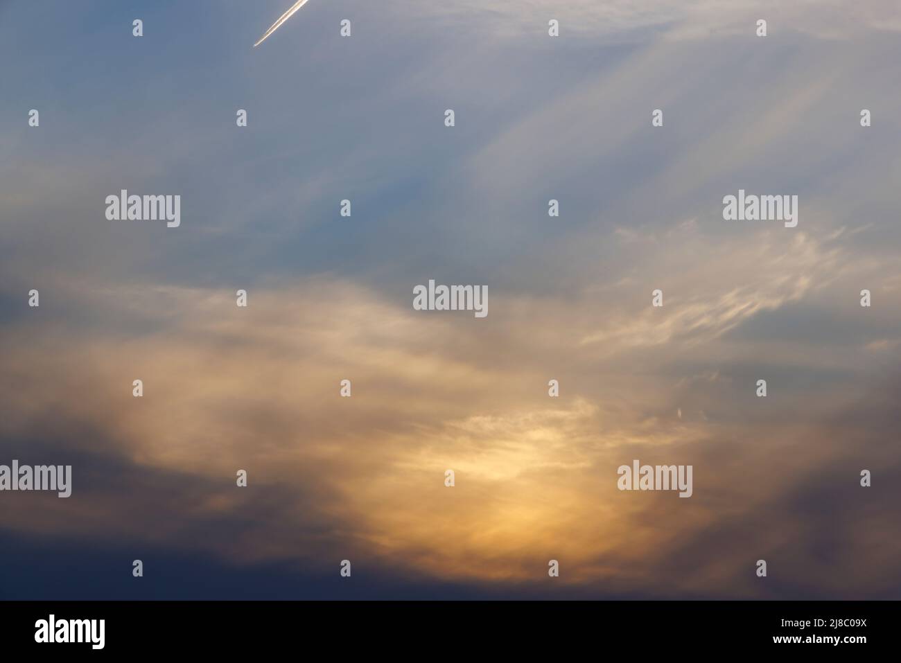 Sun disappearing behind cloud cover Stock Photo - Alamy