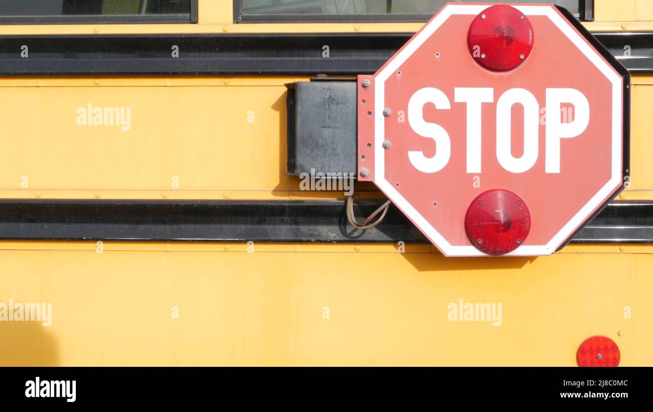 Red stop sign, yellow school bus in California, USA. Traffic warning on ...