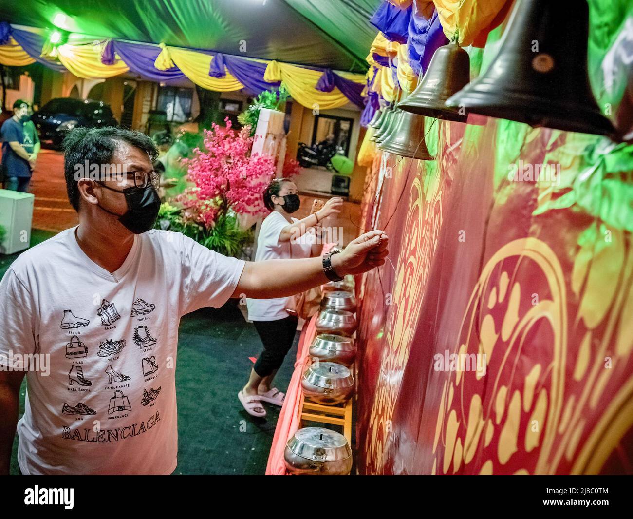 Buddhist devotees are seen ringing the 'Baby Buddha' bells during a ...